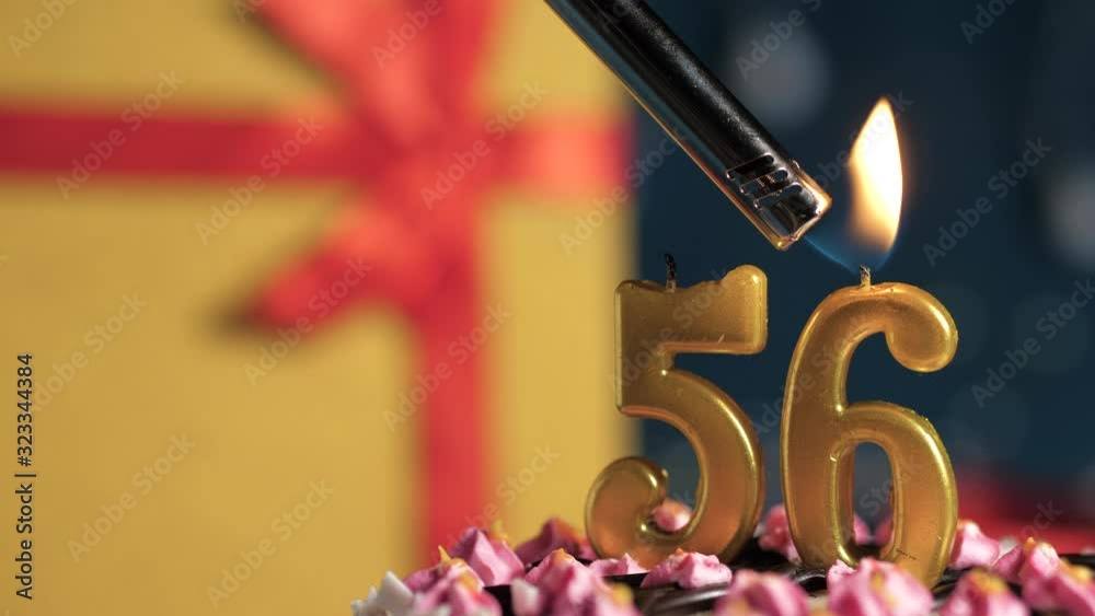 Birthday cake number 56 golden candles burning by lighter, blue ...