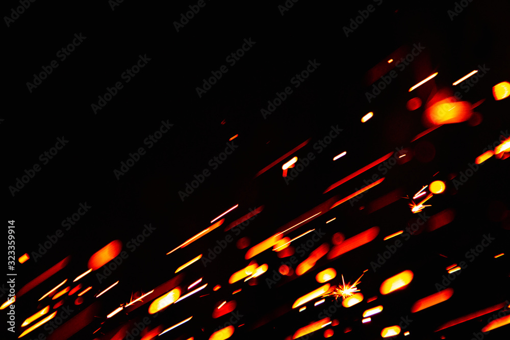 Burning red hot sparks fly from large fire in the night sky. Beautiful ...