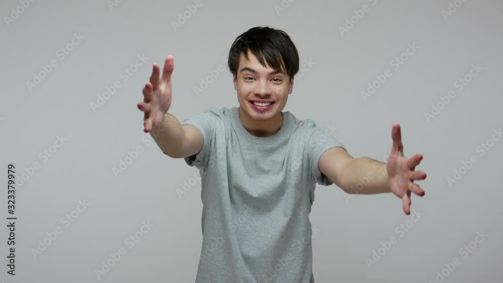 Let me hug you! Young good-natured friendly man in T-shirt stretching ...