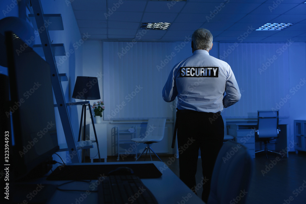 Professional security guard at work in dark office Stock Photo | Adobe ...