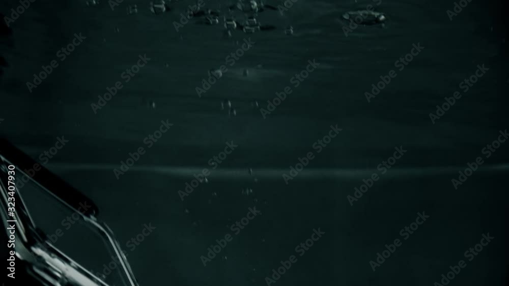 A waterproof action camera falling in dark water. Steady camera ...