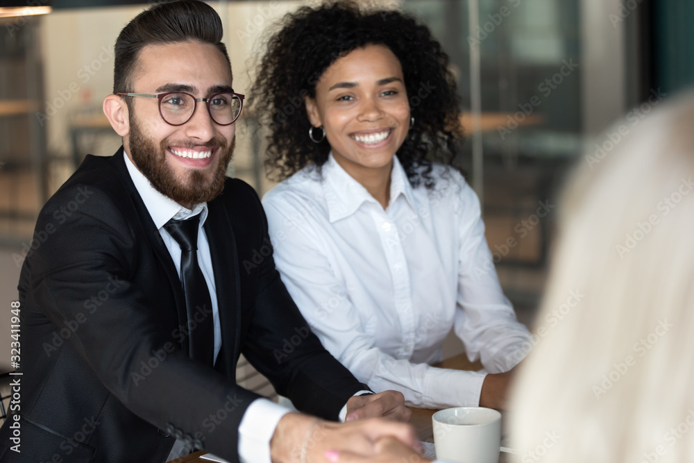 Arabian businessman greeting partner shaking hands seated at office ...