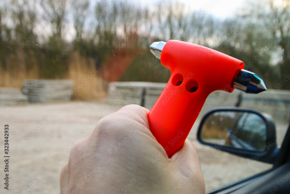 Safety hammer being used to smash window glass during car crash ...