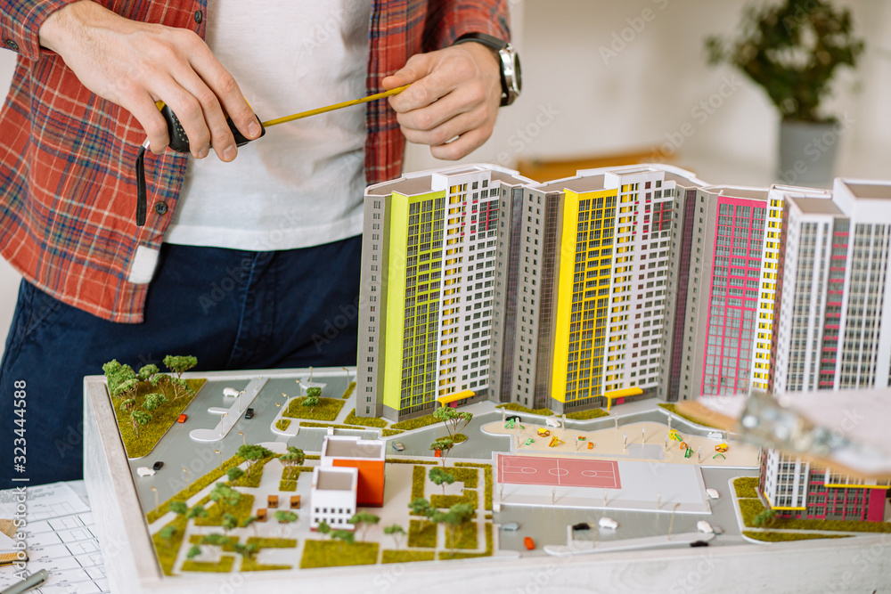 young caucasian builder assemble complex building model, construction ...