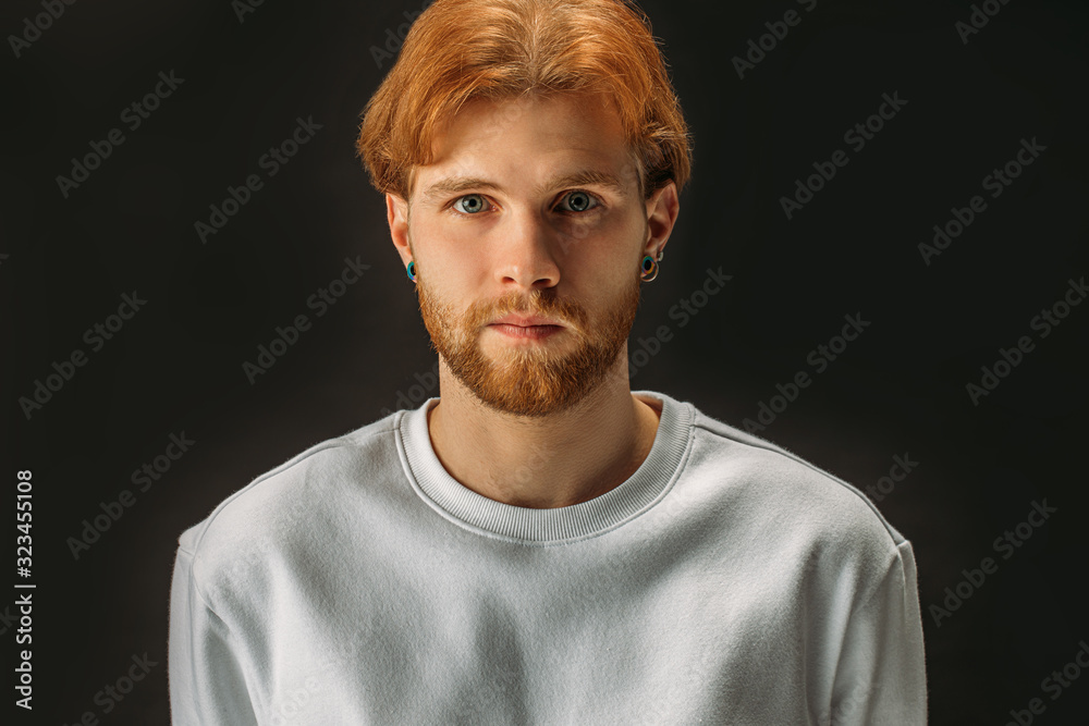 confident, serious redhead guy isolated over black background. young ...