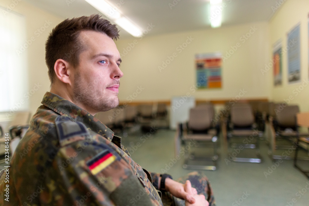 German soldier sits in a classroom . German word Bundeswehr, means ...
