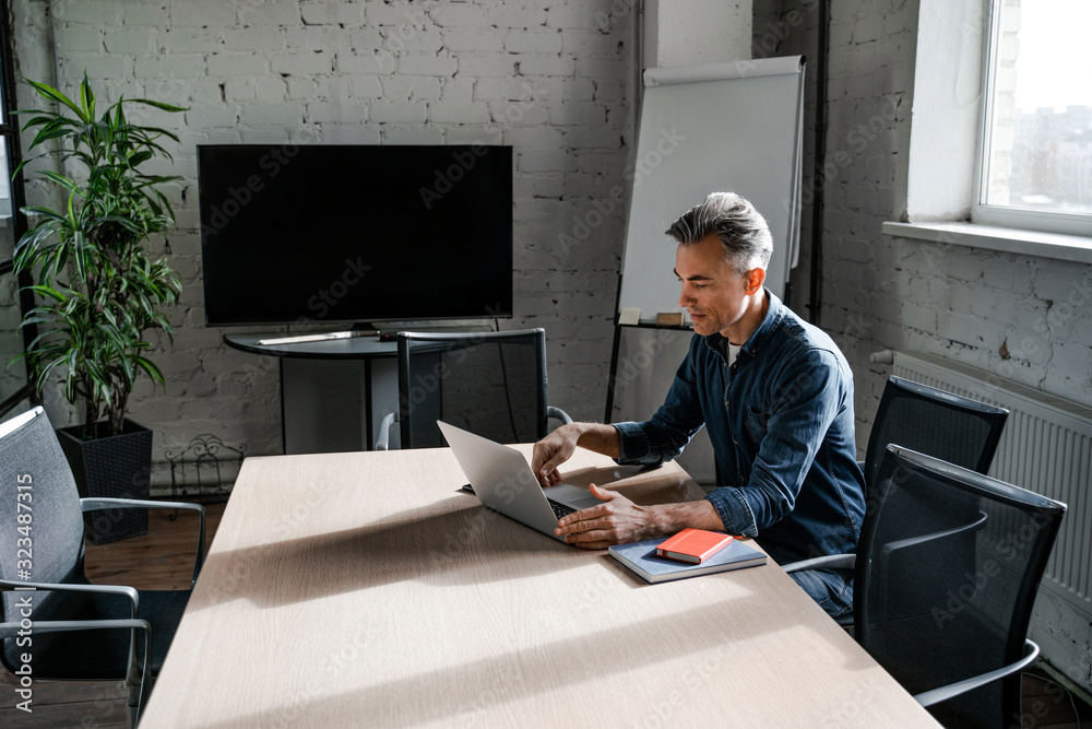 Concentrated busy adult business man work in office meeting room alone ...