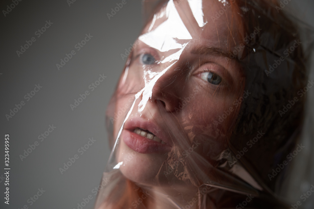 Portrait of a young girl with a plastic bag on her head. The concept of ...