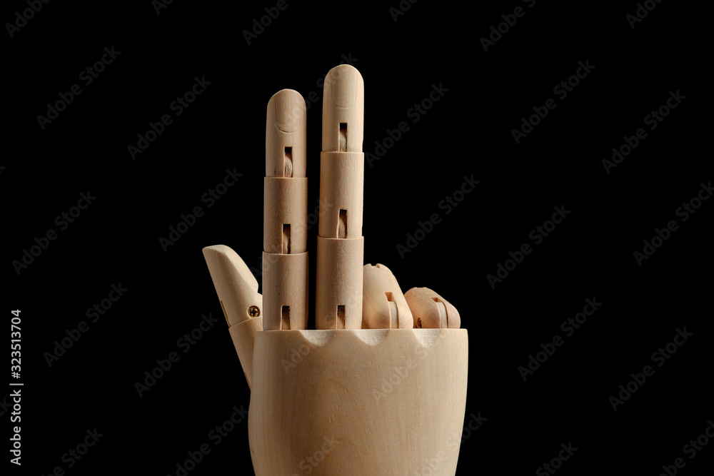 Wooden hand of mannequin for drawing shows two fingers on a black ...
