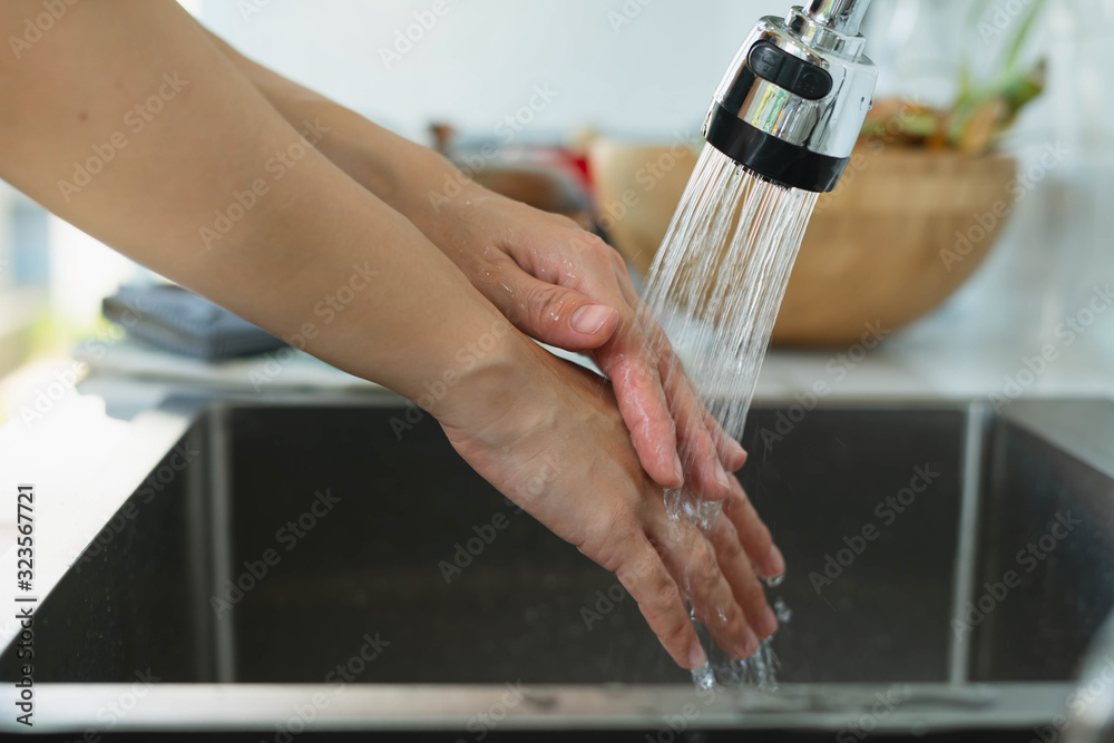 Mid section of woman washing hands in the kitchen. Woman Washing Her ...