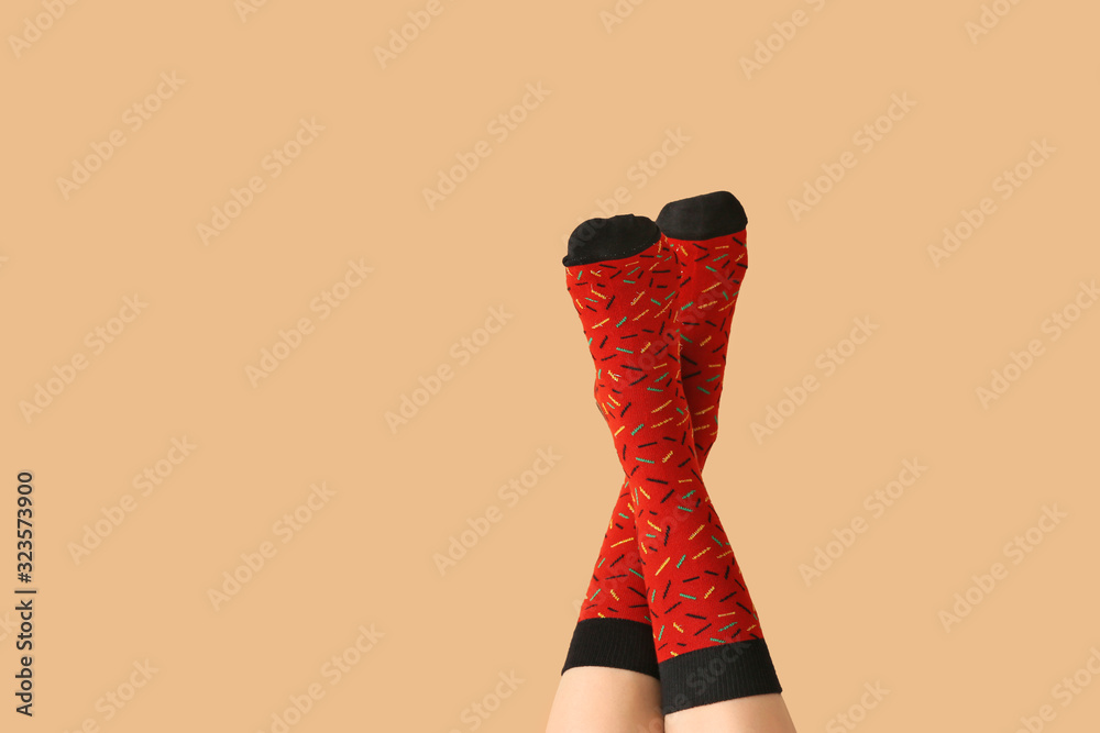 Legs of young woman in socks on color background Stock Photo | Adobe Stock