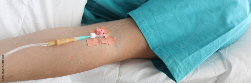 Focus on males hand with intravenous injection of catheter. Serious ...