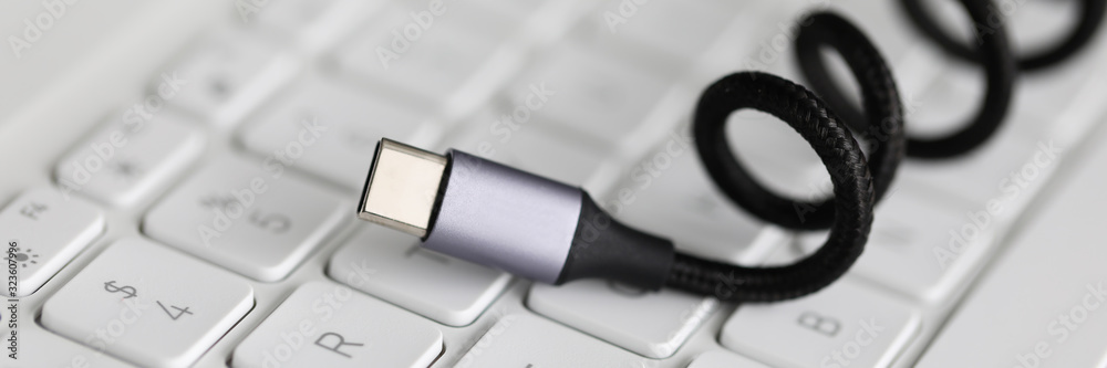 Usb type c cable against laptop keyboard background. Fast charge ...