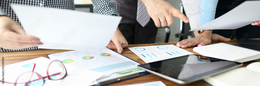 Close-up of people hands and important business paper lying on wooden ...