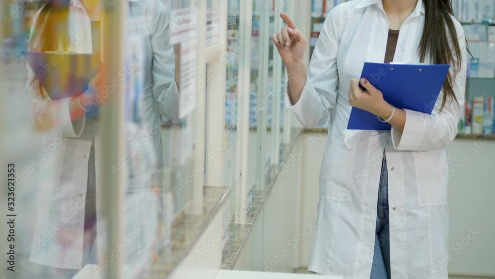A young girl promoter makes a reconciliation of drugs in a pharmacy ...