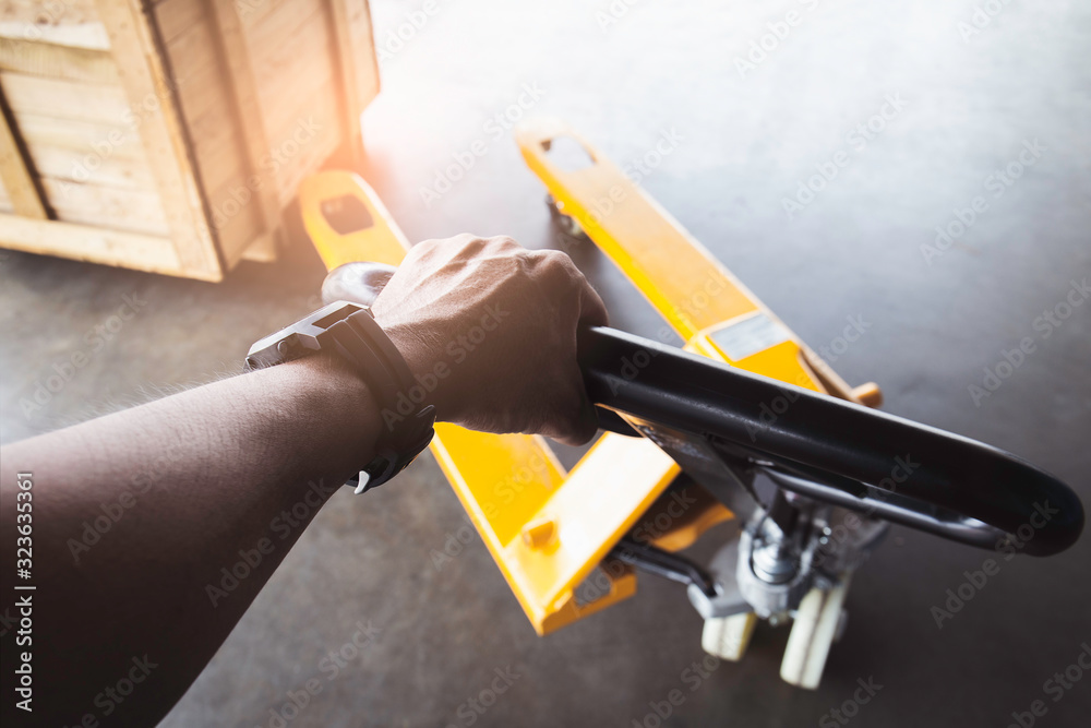 Worker are using hand pallet truck loading shipment goods. Stock Photo ...