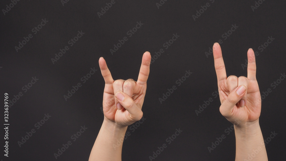 Male model is doing rock hand sign with two hands on blackground. Stock ...