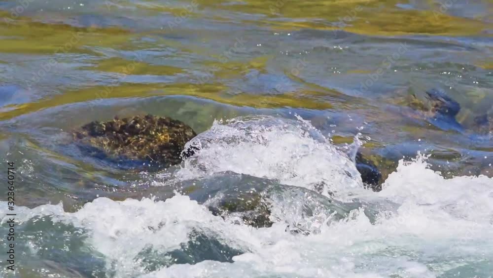 Beautiful close-up 50 FPS footage of crystal clear water flowing over a ...