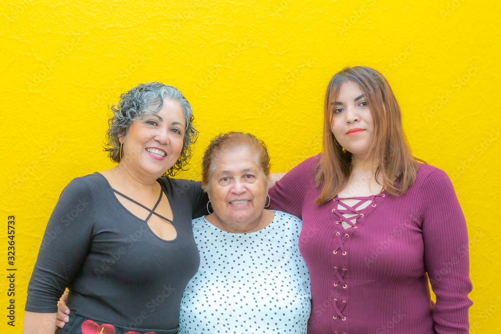 Daughter, grandmother and granddaughter hugging looking at the camera ...