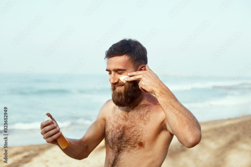 Handsome Man with beard, In Sunglasses Sunbathing With Sunscreen Lotion ...