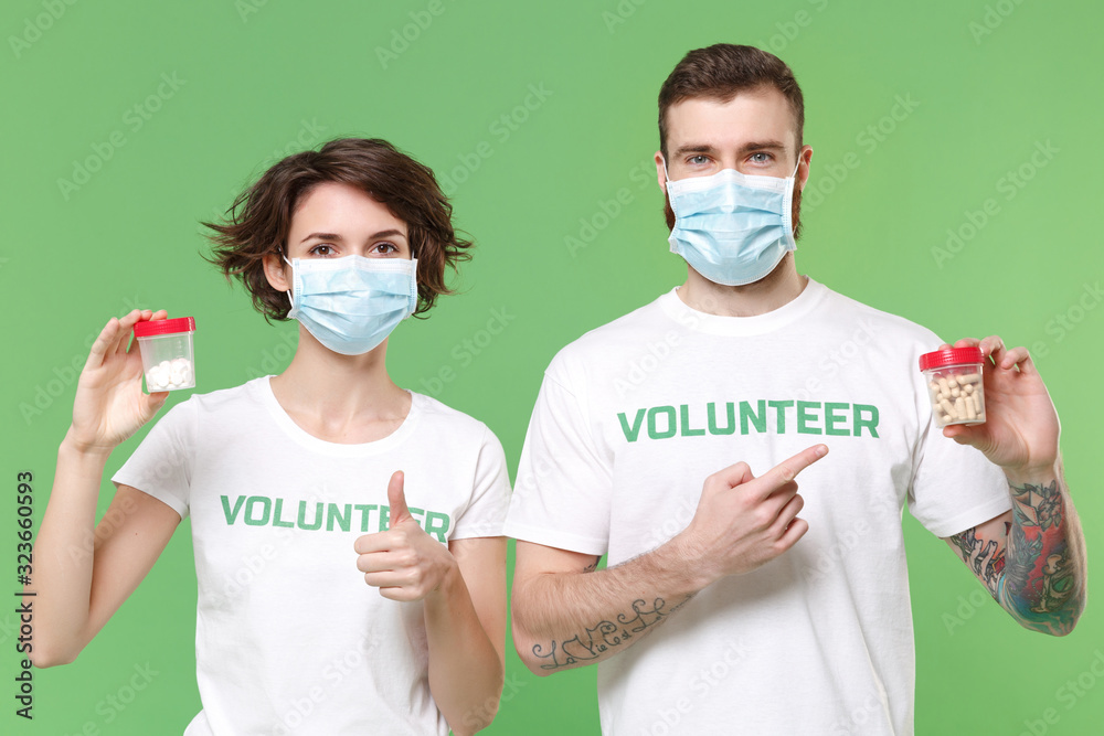 Two friends couple in volunteer t-shirt isolated on pastel green ...