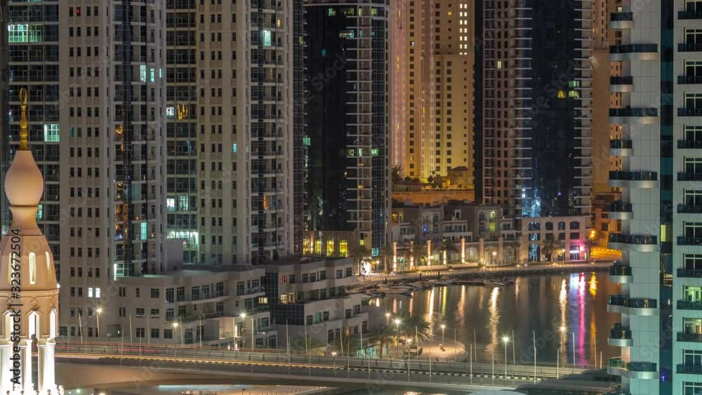 Dubai Marina with illuminated skyscrapers and promenade aerial night to ...