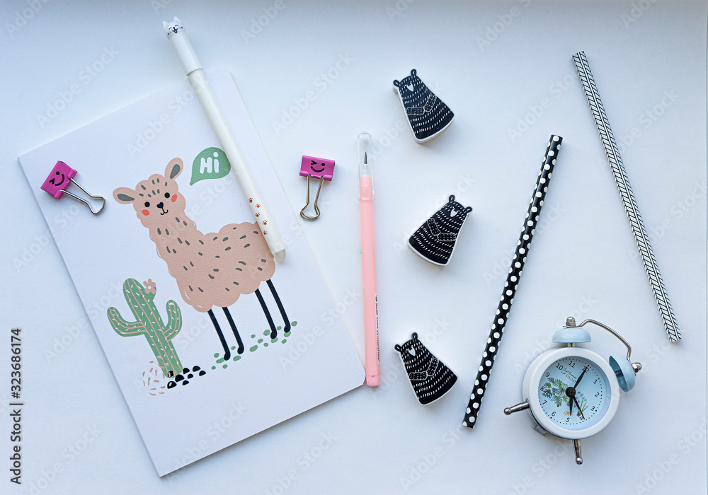 A light blue pencil, an alarm clock, flash card and paper clips lie on ...