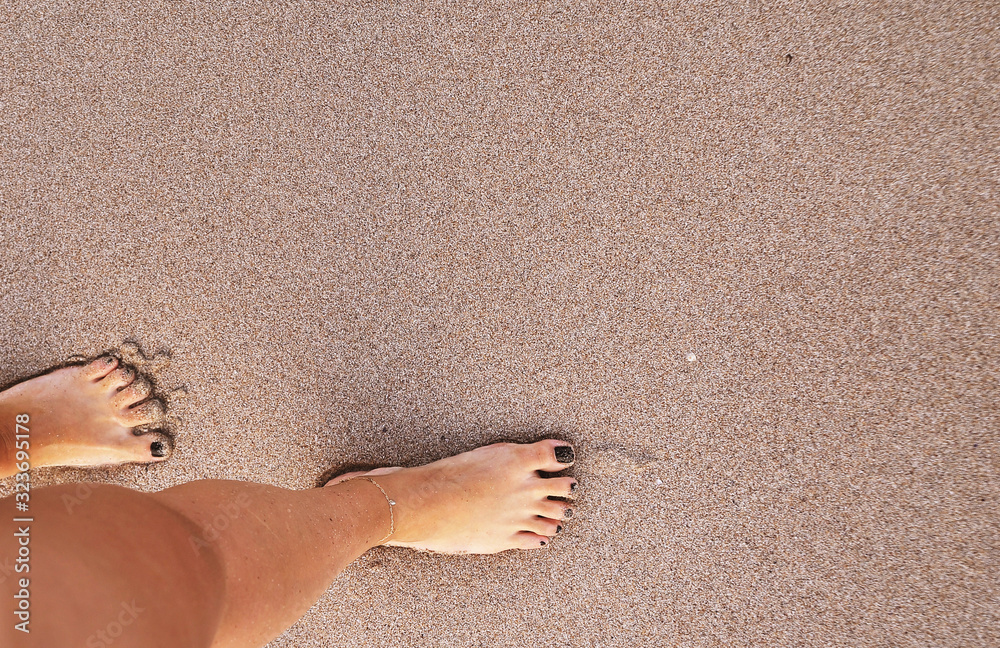 Female legs on sand texture. Stock Photo | Adobe Stock