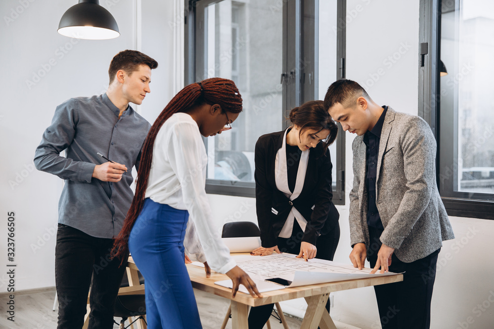 Group of young male and female students sharing ideas while working on ...
