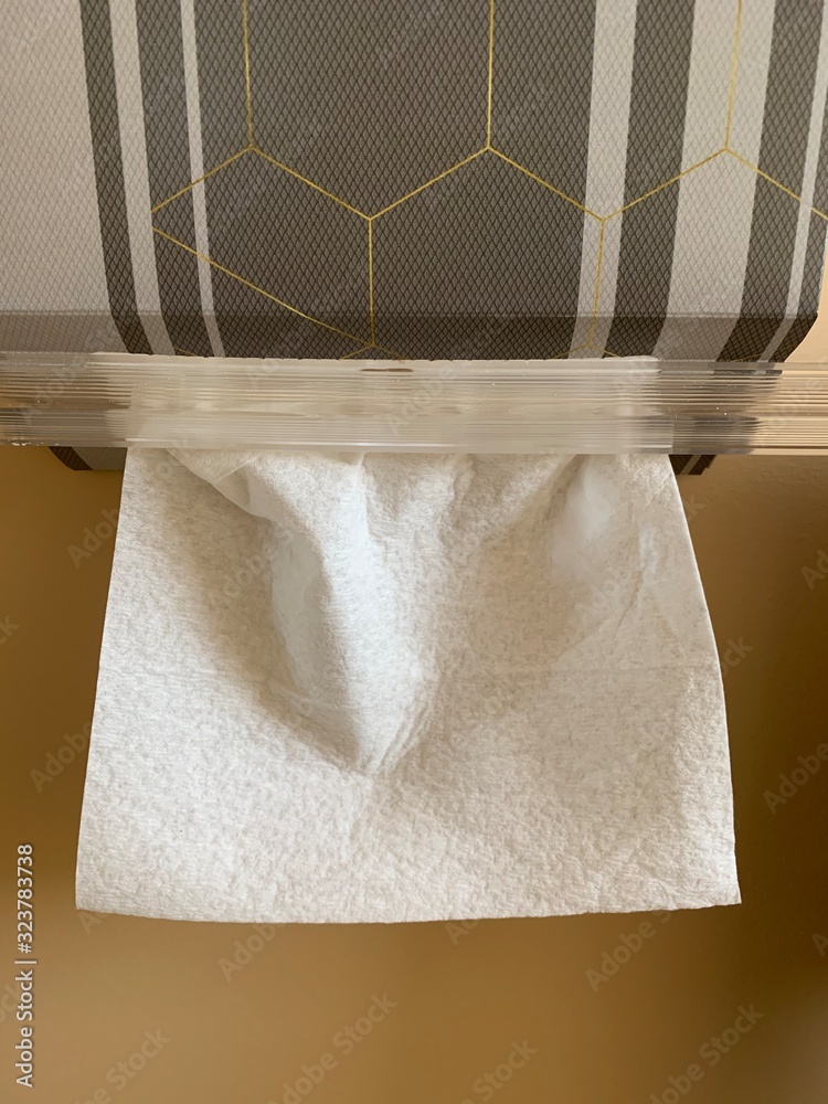 Disposable sanitary paper towels dispensing from a box in a bathroom ...