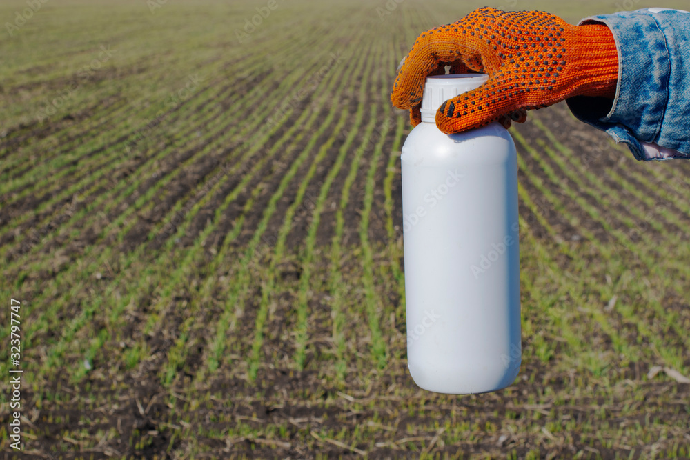 Protection of crops from pests and diseases. Bottle with a pesticide in ...