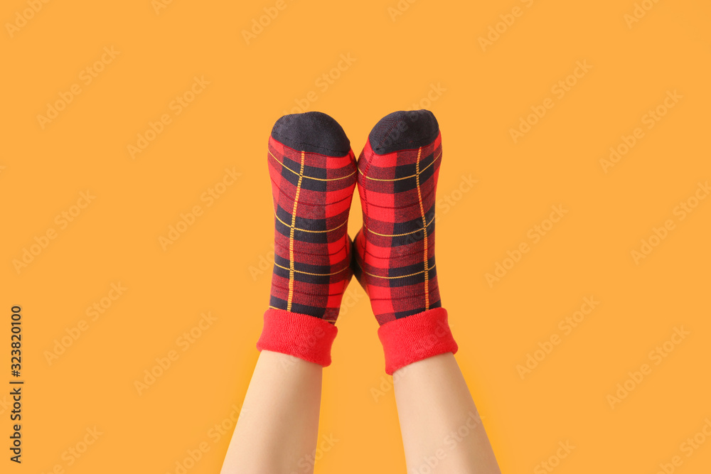 Legs of young woman in socks on color background Stock Photo | Adobe Stock