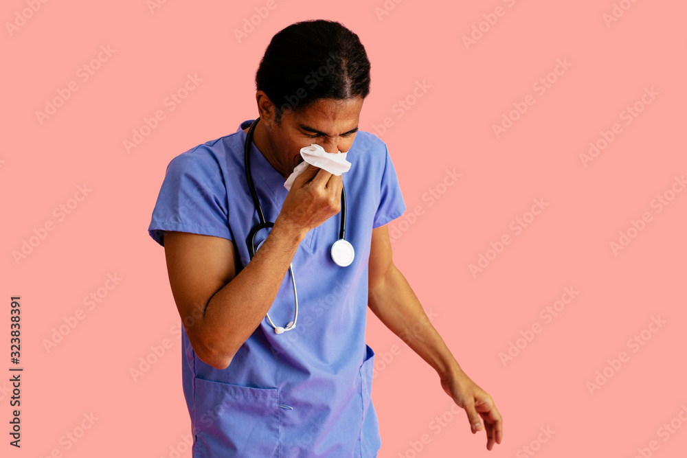 Studio portrait of a sick male doctor or nurse wearing blue scrubs and ...