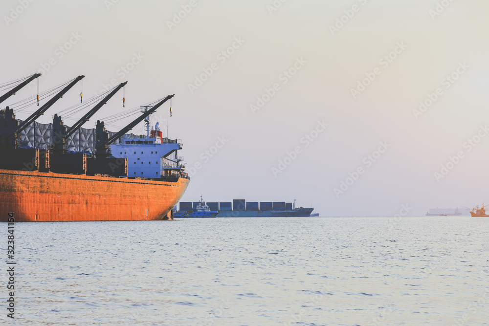 Cargo ship alongside in shipyard with sunset background under ship ...