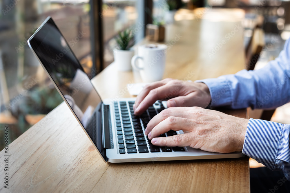 Hands typing on laptop computer keyboard, person writing email or ...