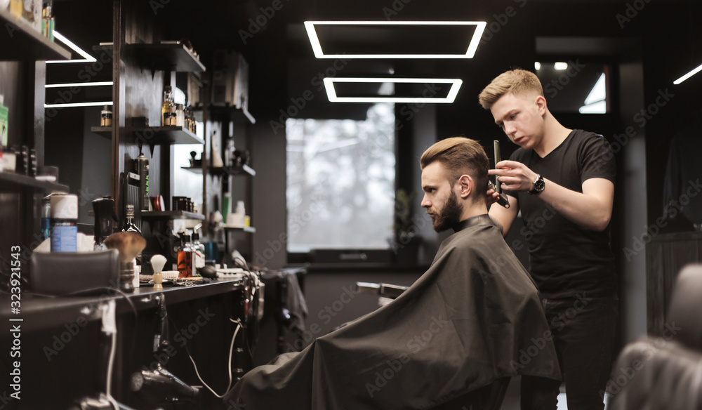 Foto de Hands of the pro. Profile photo of a young barber trimming his ...