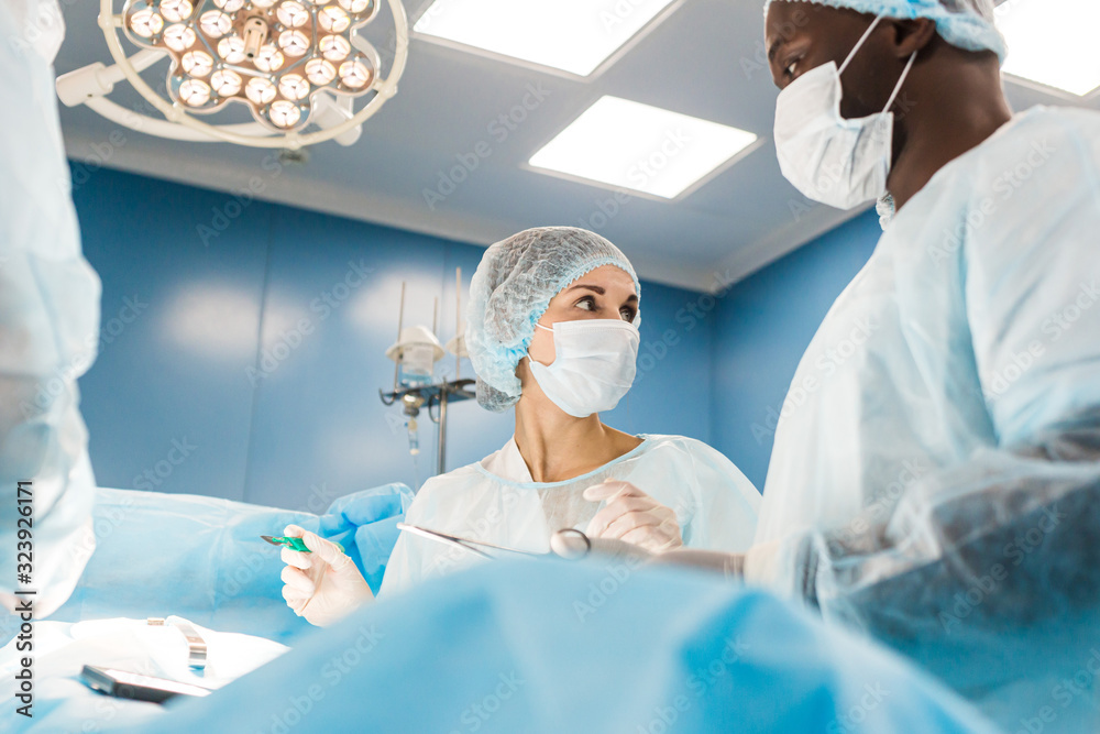 An international team of doctors performs a complex surgical operation ...