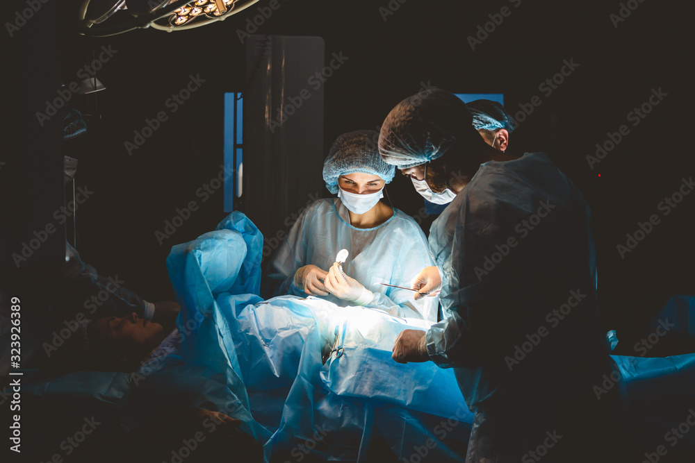 An international team of doctors performs a complex surgical operation ...