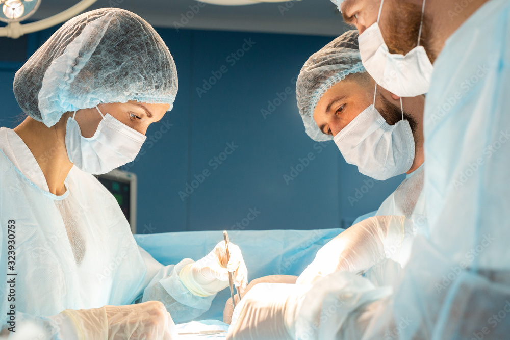 An international team of doctors performs a complex surgical operation ...