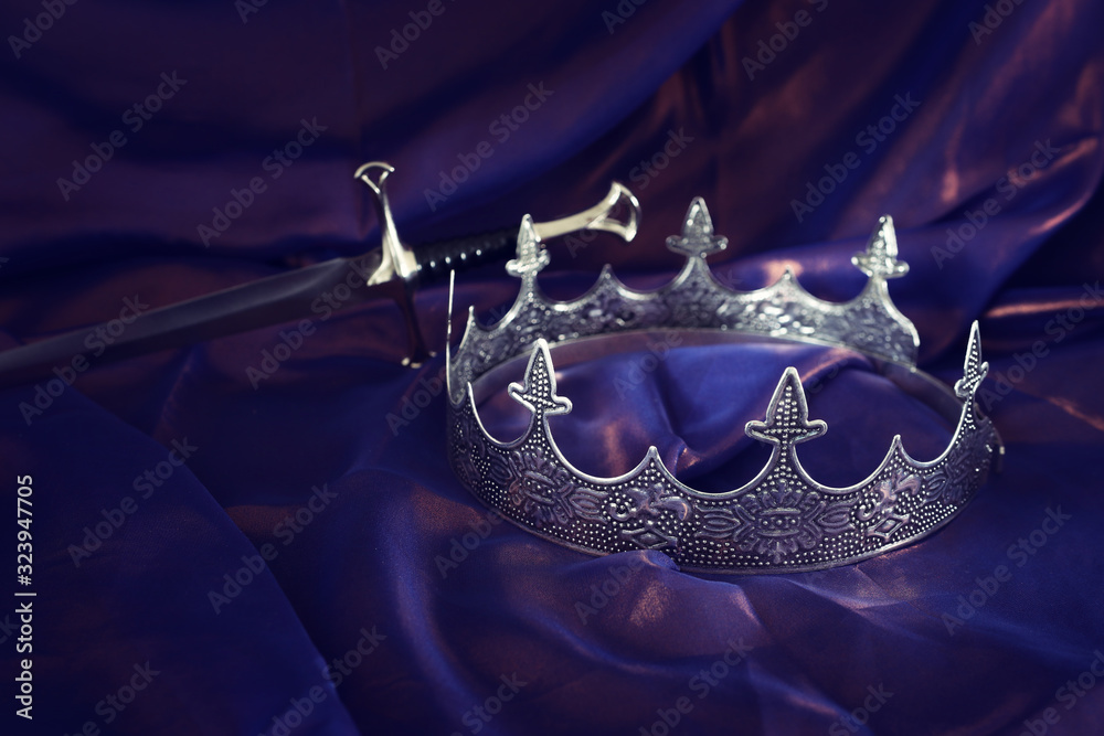 low key image of beautiful queen/king crown and sword over dark royal ...