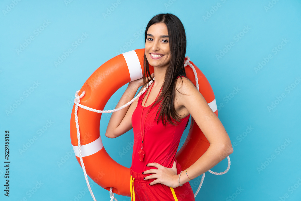 Lifeguard woman over isolated blue background with lifeguard equipment ...