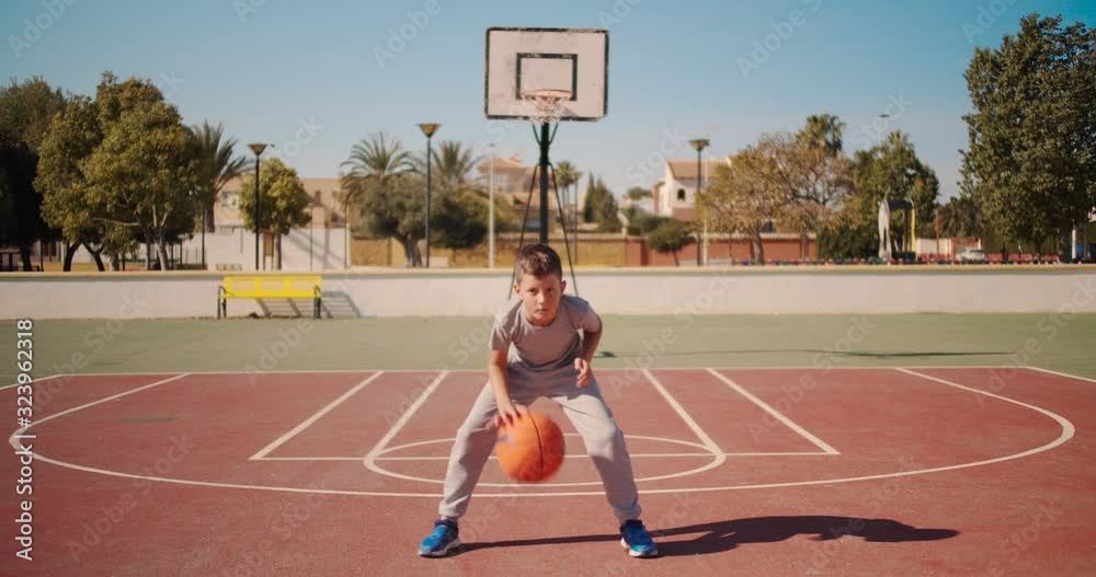 Cute kid hiting a basketball ball. Boy practicing shooting a basketball ...
