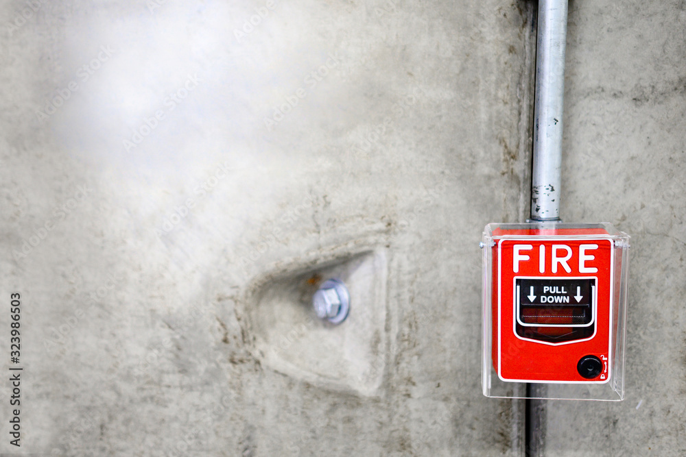 Red fire alarm switch on concrete wall in office building. Industrial ...