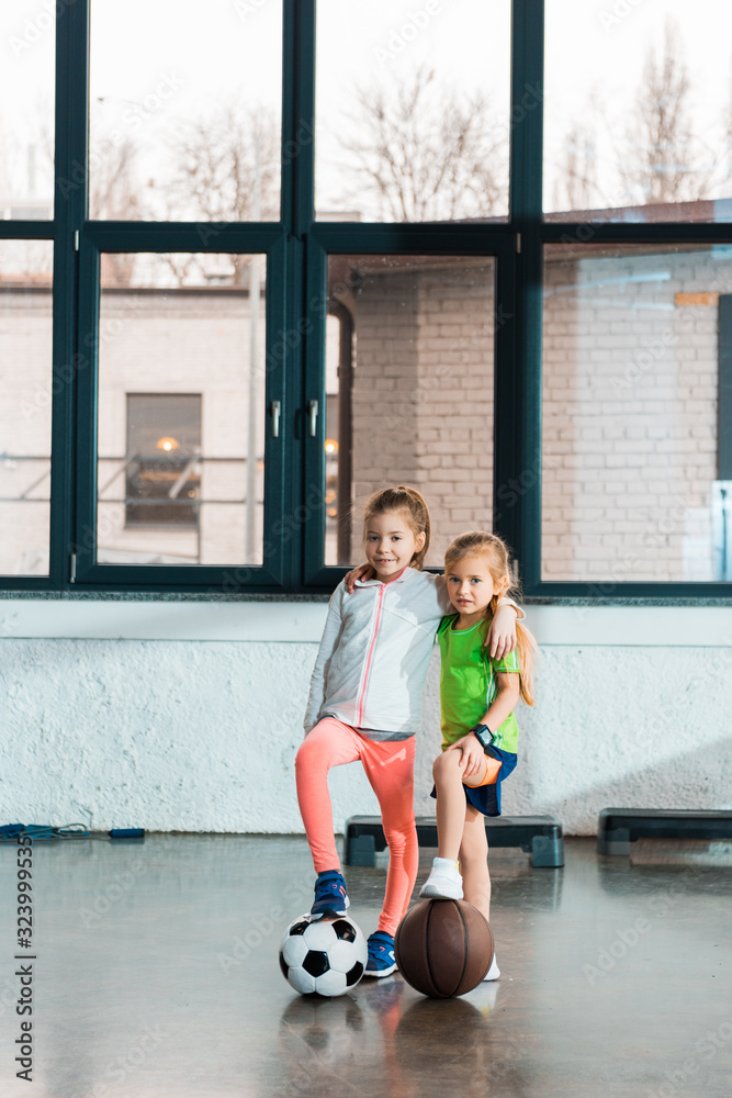 Children hugging and putting legs on balls in gym Stock Photo | Adobe Stock