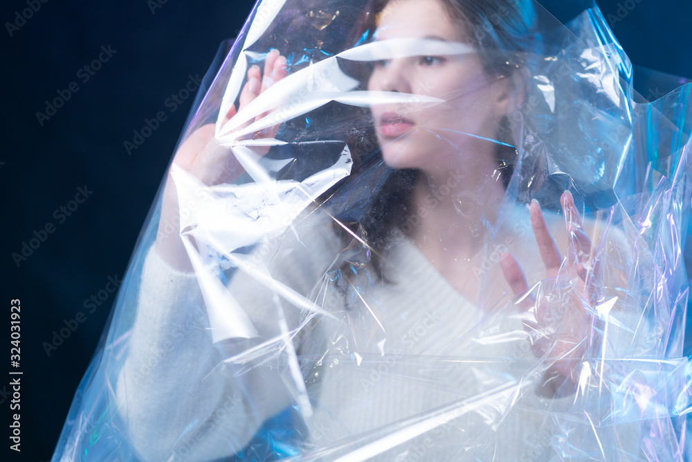 High Fashion model girl posing in studio through transparent ...