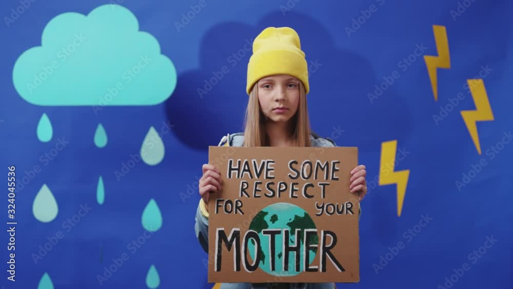 School girl ecology volunteer showing an encouraging greenpeace poster ...