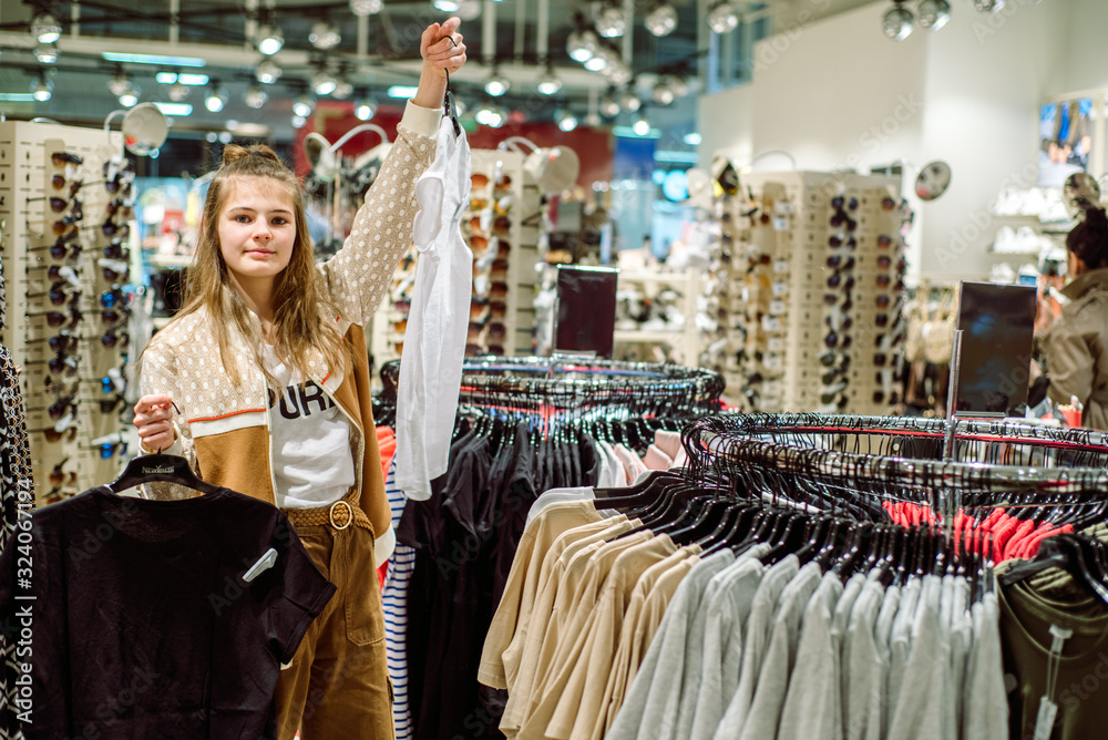 Shopping concept .teenager girl tries on and buys a sports shirt in the ...