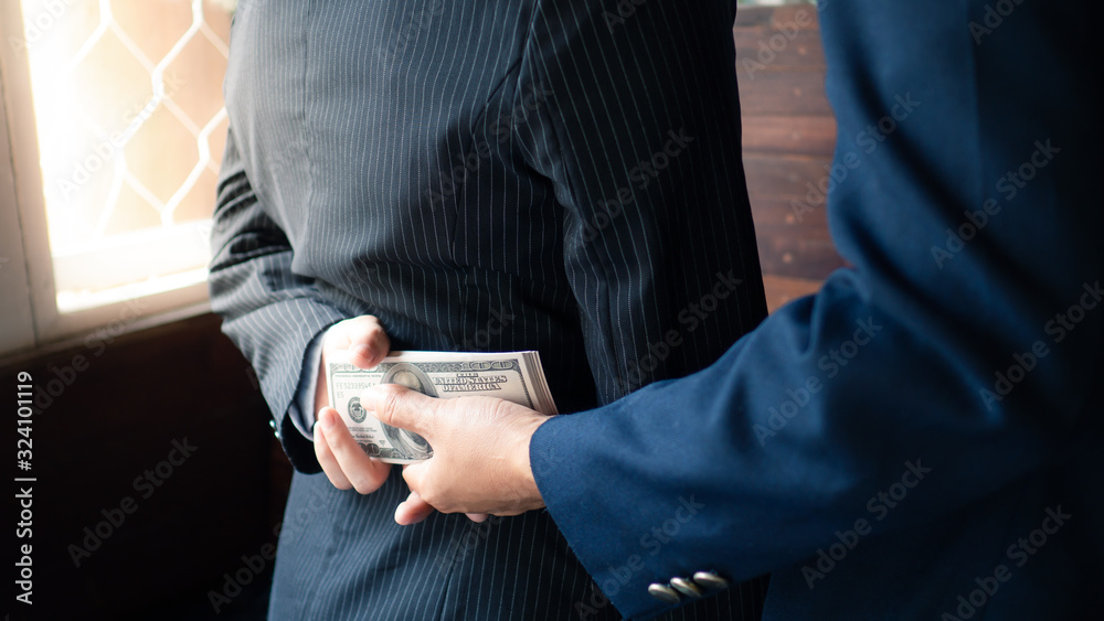 Two businesswomen shaking hands while one man giving money and receive ...