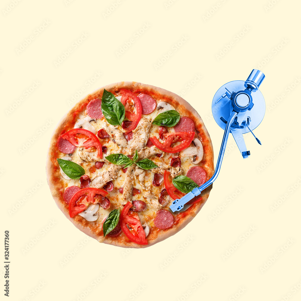 Pizza as a vinyl on DJ's controller on yellow background. Copyspace to ...