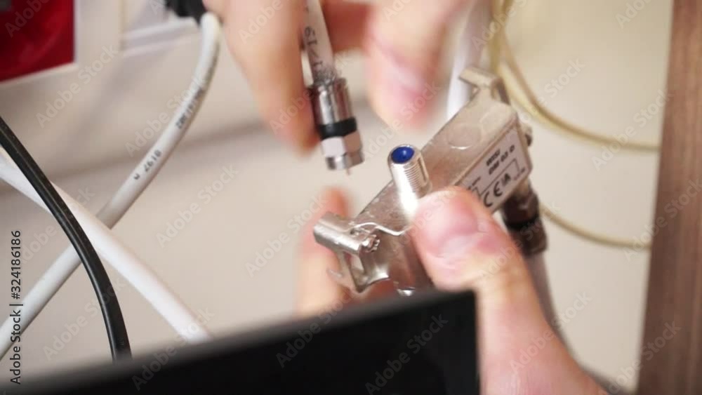 Electrician unplugging television cable from signal splitter, close up ...